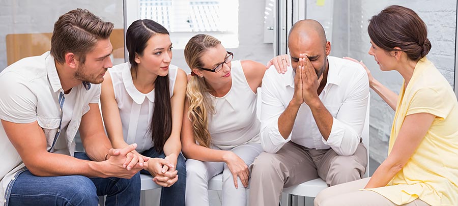 Business team sitting together supporting sad colleague in the office ...